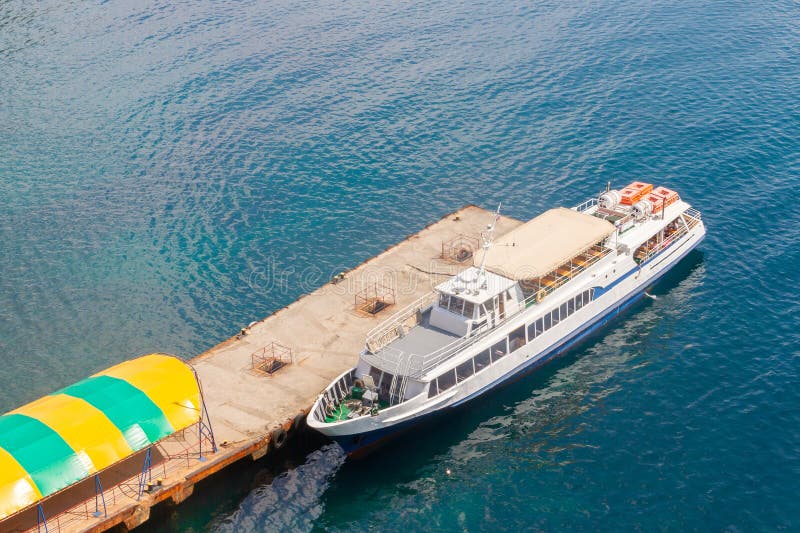 Excursion Boat Moored at the Pier on the Coast of the Blue Sea on a ...