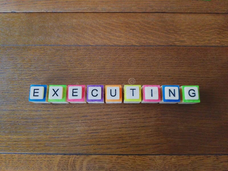 Executing Word in Colorful Letters on Wood Background Stock Photo ...