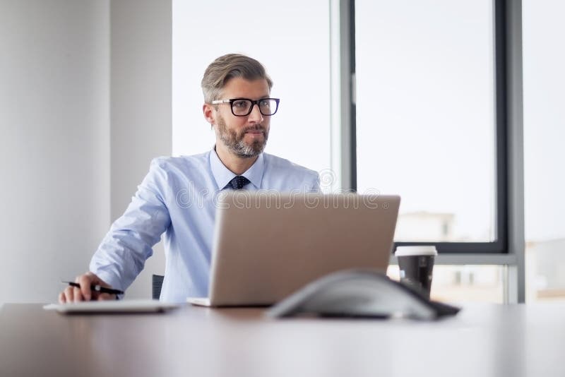 Executive Businessman Sitting in a Modern Office and Using Notebook for ...