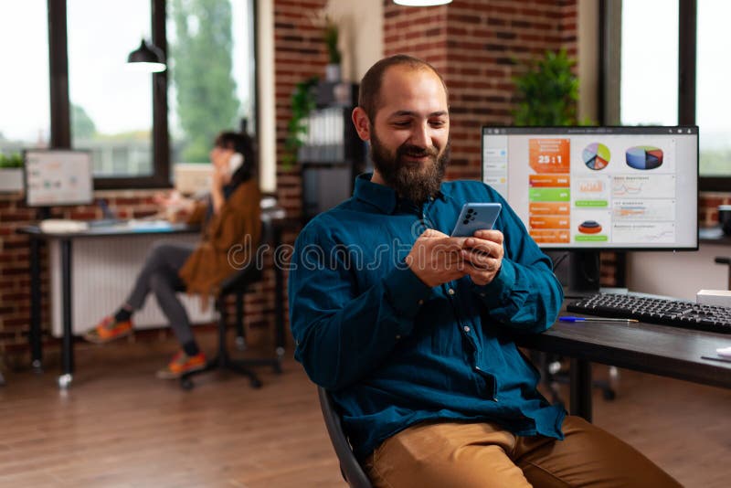 Executive Manager Sitting at Desk Table Holding Modern Phone Reading ... Executive Manager Sitting at Desk Table Holding Modern Phone Reading ...