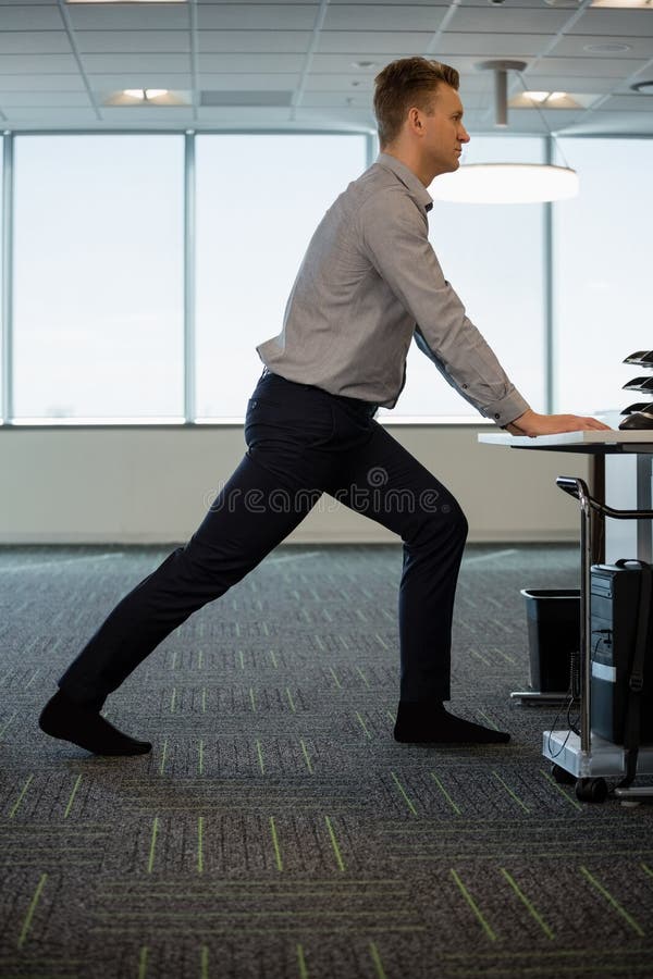 Executive Performing Stretching Exercise at Desk Stock Photo - Image of ...