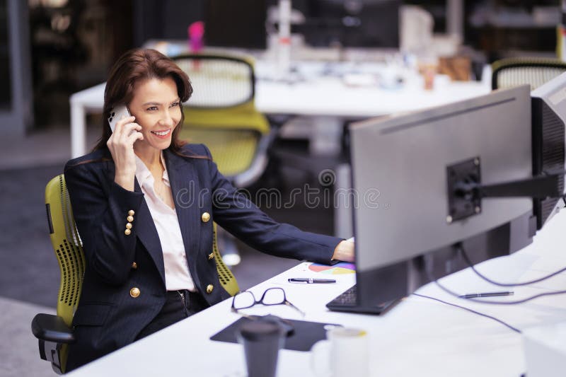 Executive Professional Woman Sitting at Desk Surrounded by Computers ...