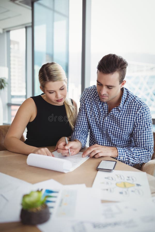 Executives Discussing Over Paper at Desk Stock Photo - Image of ...