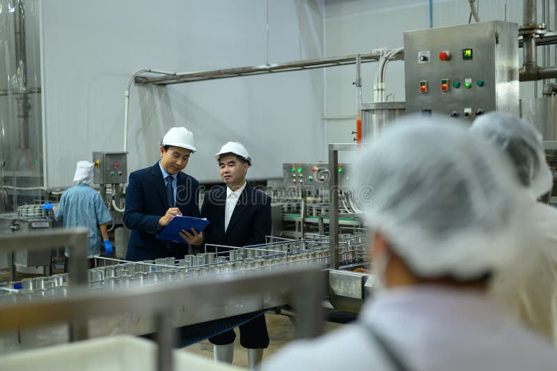 Executives in Safety Helmets Inspecting the Production Line in Seafood Manufacturing Facility ...