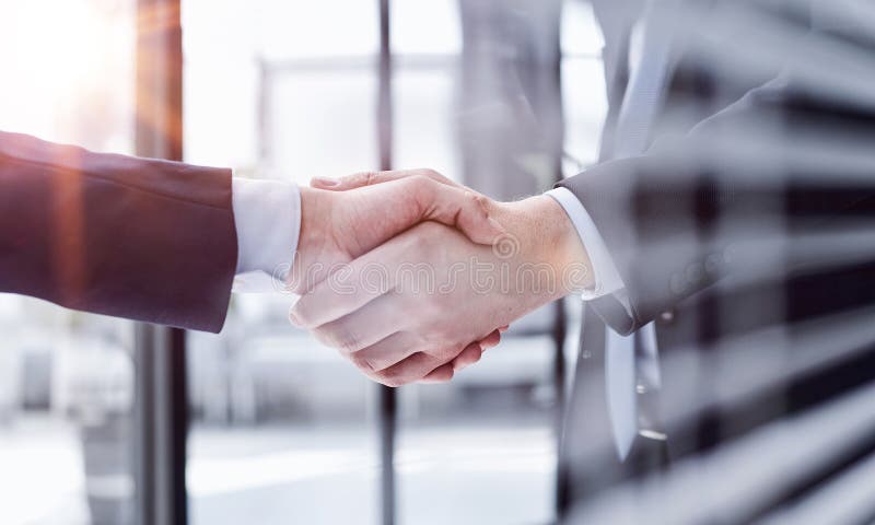 Executives Shaking Hands in Front of Their Manager and a Colleague ...