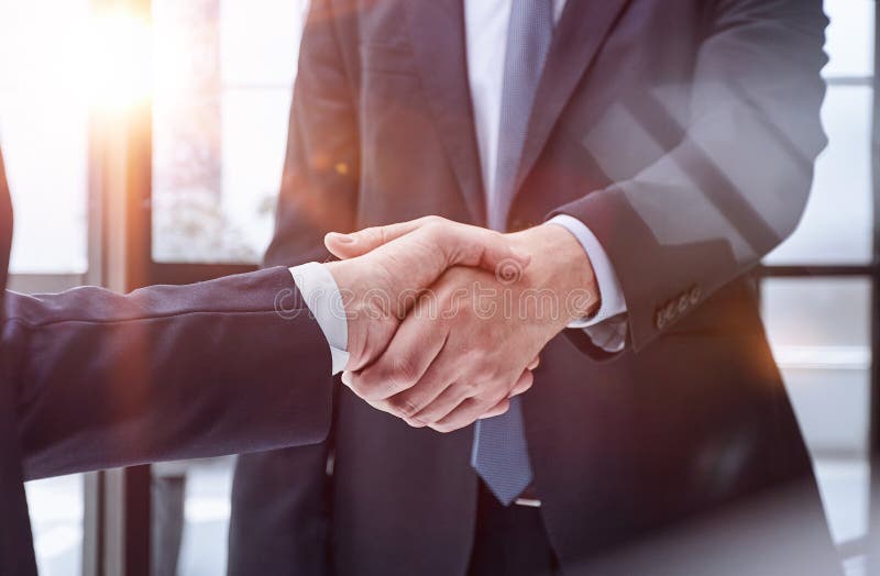 Executives Shaking Hands in Front of Their Manager and a Colleague ...