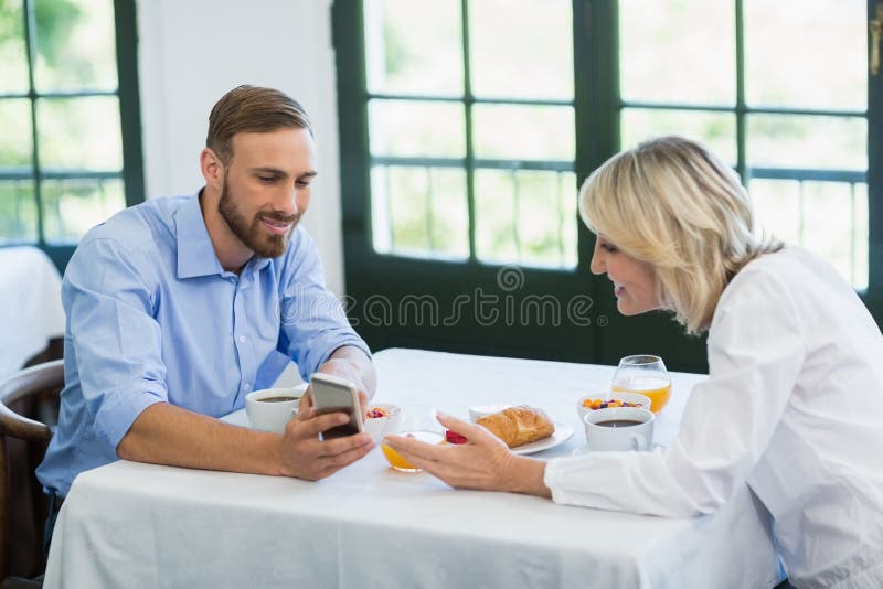 Executives Using Mobile Phone in a Restaurant Stock Photo - Image of ...