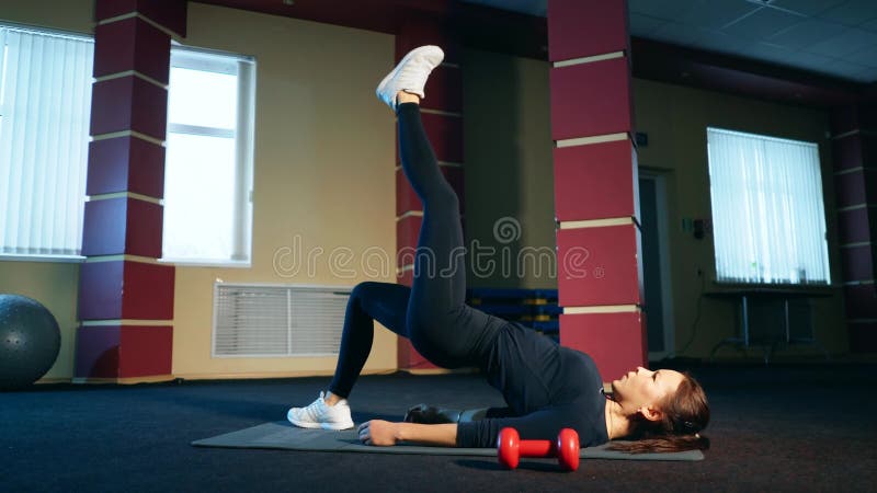 Lifting Pelvis while Lying on a Mat in Nature. Athletic Woman Doing ...