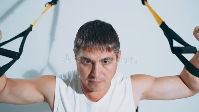 A Man Engages in the Gym Using TRX Loops. Exercise on the Muscles of ...