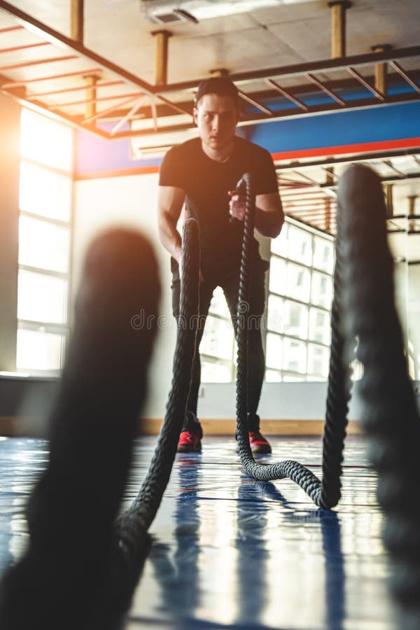 Exercise with Ropes. the Athlete is Training in the Gym. Stock Photo ...