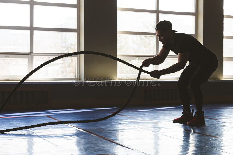 Exercise with Ropes. the Athlete is Training in the Gym Opposite Large ...