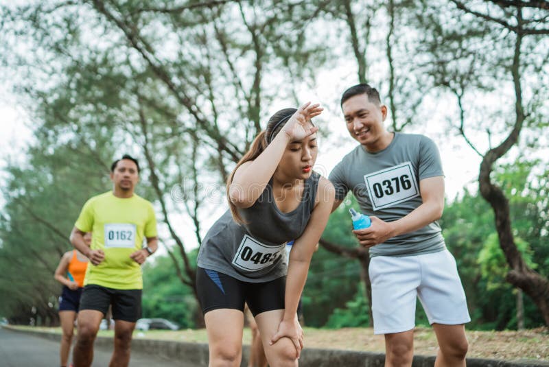 Exhausted Female Getting Help from Other Participant Stock Photo ...