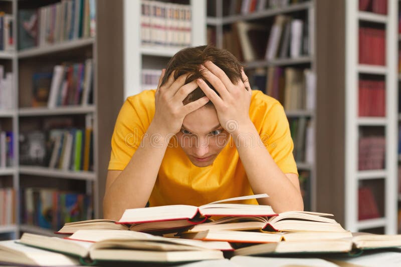 Exhausted Guy Holding His Head and Reading Book in Library Stock Image ...
