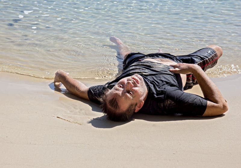 Exhausted Man Lying on the Beach Stock Photo - Image of lost, lonely ...
