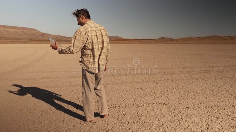 Exhausted man in a desert stock video. Video of drink - 297453469