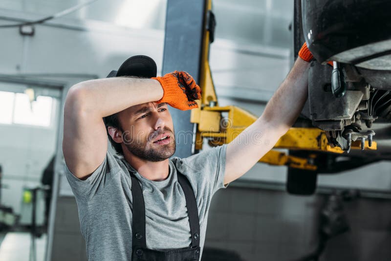 Exhausted Mechanic in Uniform Repairing Car Stock Photo - Image of ...