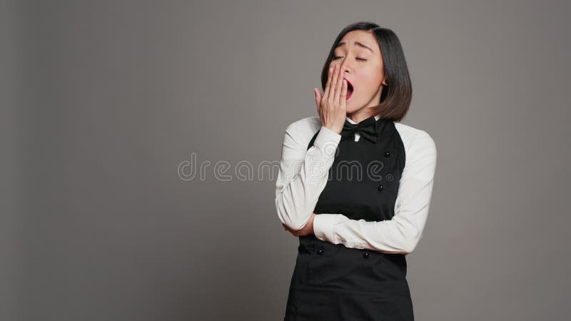 Exhausted Waitress with Apron Yawning Over Grey Background Stock ...
