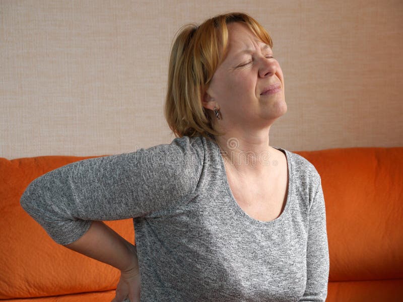 Exhausted Woman Holds Her Sore Lower Back with Her Hand Stock Photo ...
