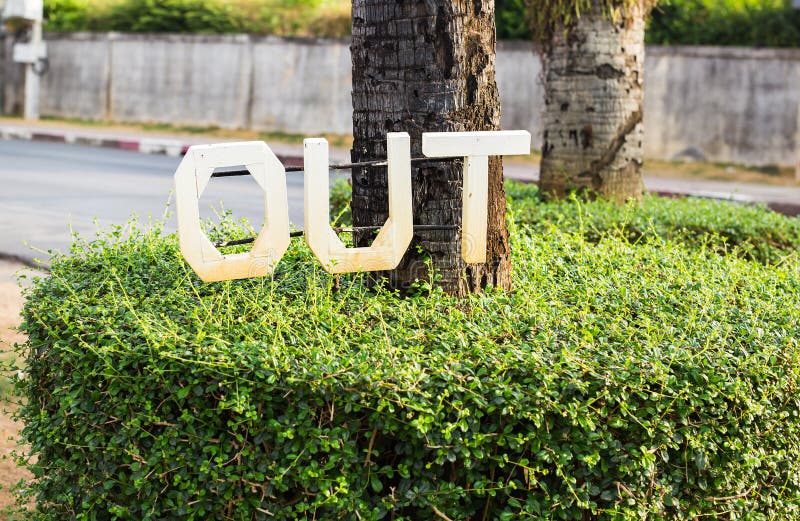 Exit or Out Sign Mounted on a Green Bush Stock Image - Image of ...