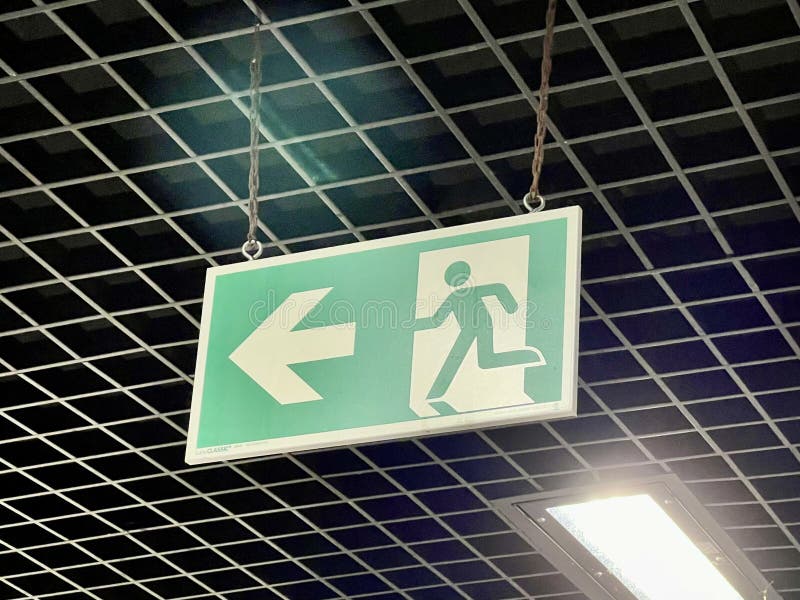 Exit Sign in Green and White Tones on a Dark Background, Hanging from ...