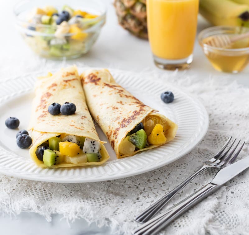 Exotic Fruit Crepes on a White Plate Surrounded by Juice, Honey and ...