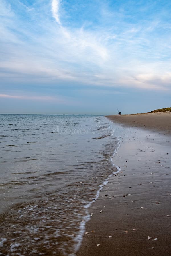Expansive Beach View with Distant Figure Under a Wide Sky Stock Photo ...