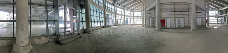 An Expansive Empty Industrial Hall Features Unfinished Concrete and ...