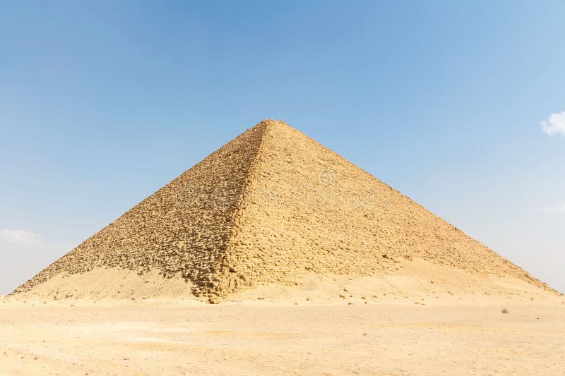 A Large Pyramid with Sand Covering it in the Desert Against a Blue Sky ...