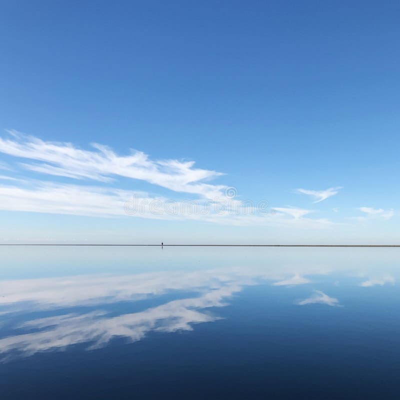Expansive Sky Meets a Perfectly Still Body of Water, Creating a ...