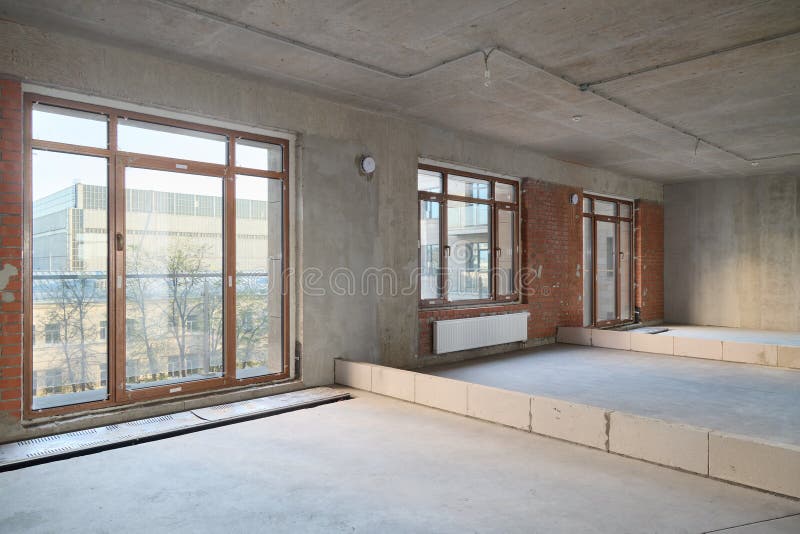 A Modern Unfinished Interior Space Featuring Large Windows Alongside ...