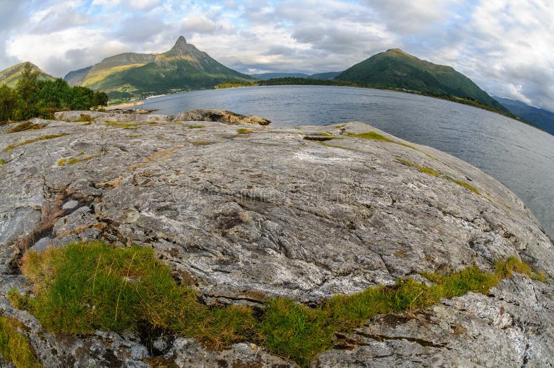 Expansive View of a the Sea and Majestic Mountains Under a Cloudy Sky ...
