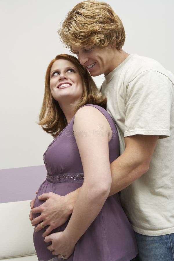 Expectant Couple Looking at Each Other while Embracing Stock Photo ...