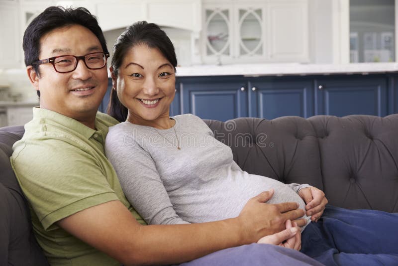 Expectant Couple Relaxing on Sofa at Home Together Stock Image - Image ...