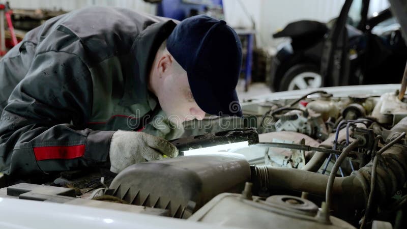 Experienced Auto Technician Checking Car Engine with Flashlight ...