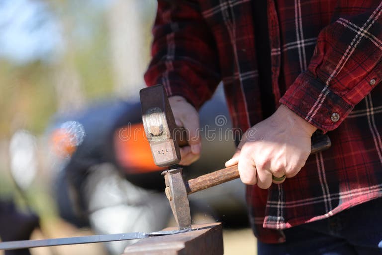 Experienced Blacksmith Punching the Sharp End of a Hammer into a Piece ...