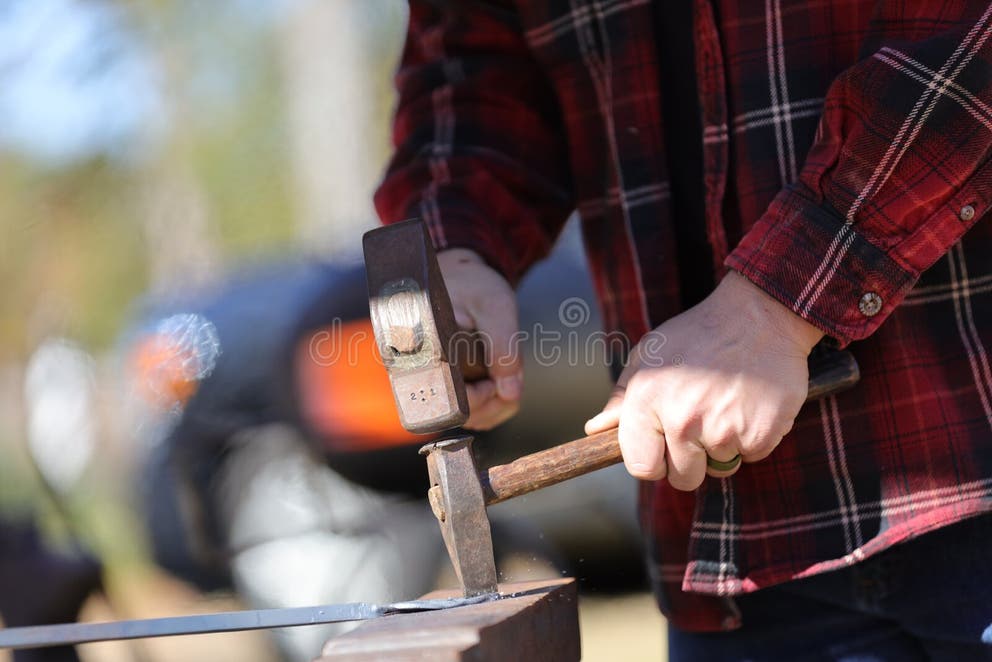 Experienced Blacksmith Punching the Sharp End of a Hammer into a Piece ...