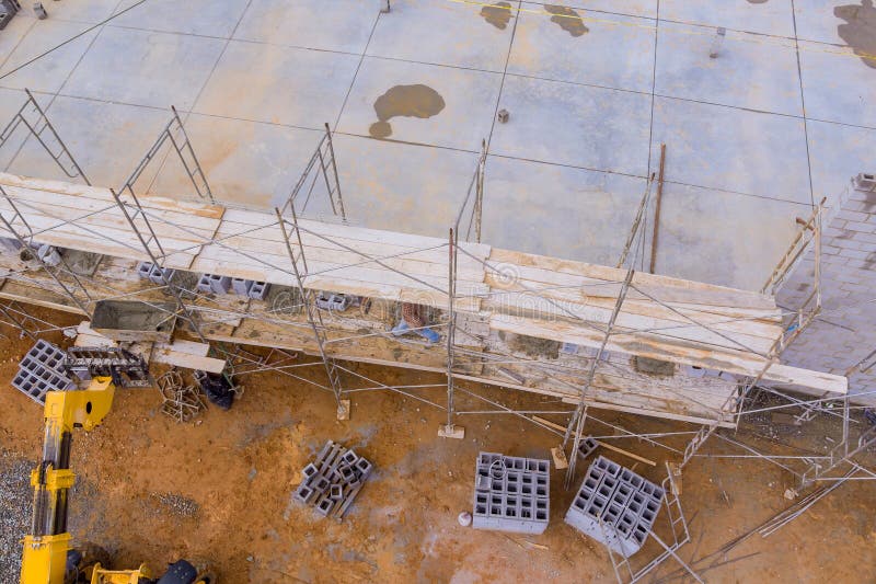 An Experienced Bricklayer Stands on Scaffolding To Construct a Working ...