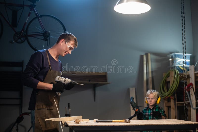 An Experienced Carpenter and His Young Apprentice Make Wood Crafts in ...