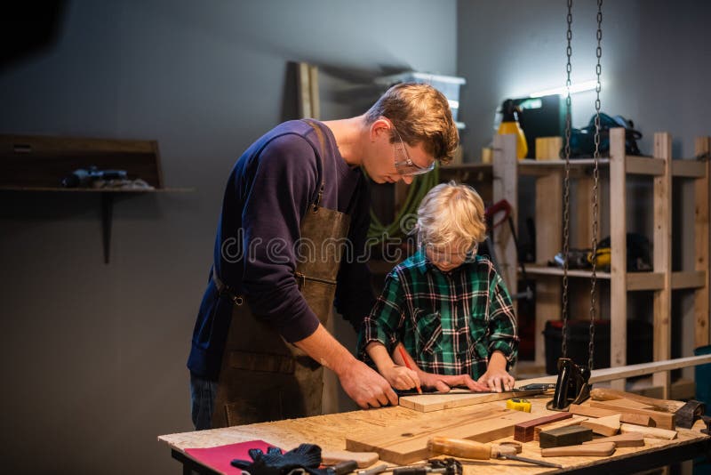 An Experienced Carpenter and His Young Apprentice Make Wood Crafts in ...