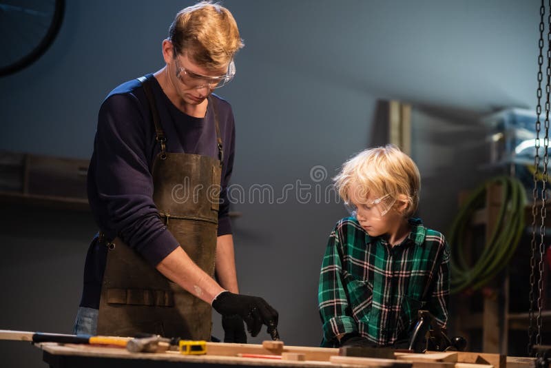 An Experienced Carpenter and His Young Apprentice Make Wood Crafts in ...