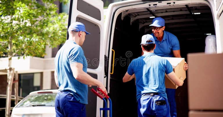 The Experienced Courier Team is Unloading Cardboard Boxes from the Van ...