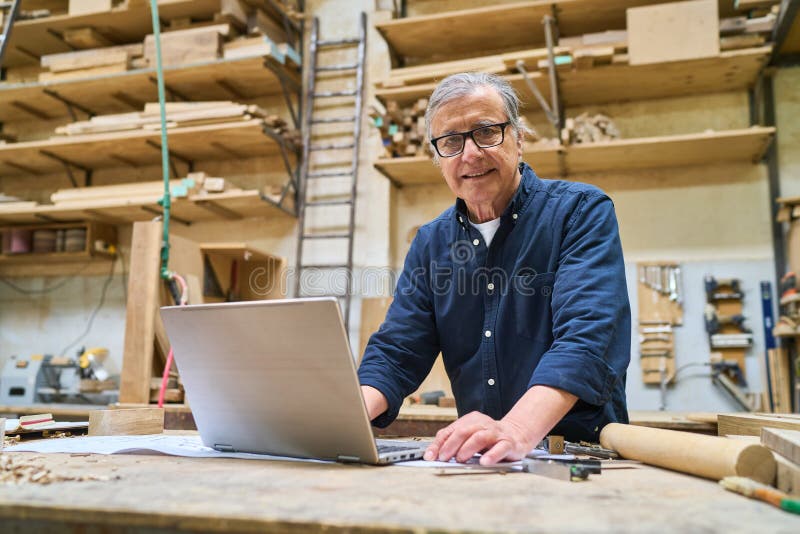 Experienced Craftsman Using Laptop in a Wood Workshop Stock Photo ...