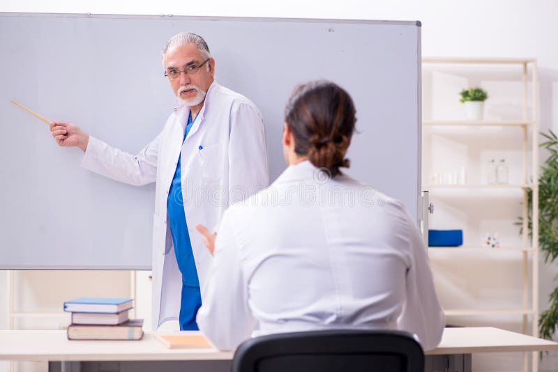 Experienced Doctor Teaching Young Male Assistant Stock Image - Image of ...