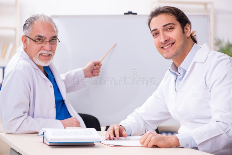 Experienced Doctor Teaching Young Male Assistant Stock Image - Image of ...