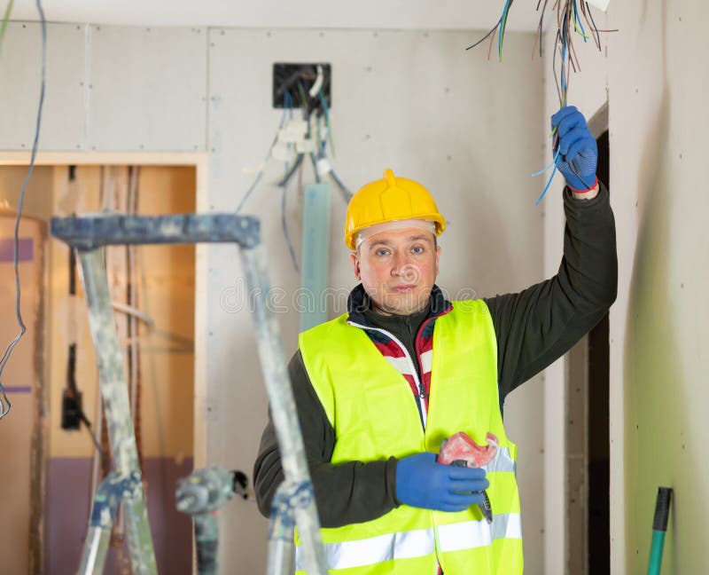 Experienced Electrician Laying Electric Wires in Building Under ...