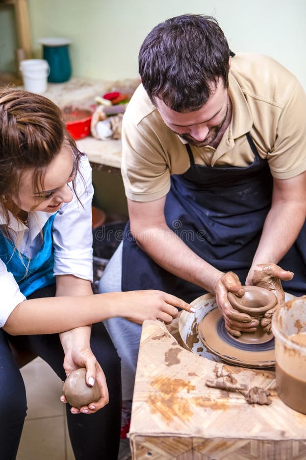Experienced Male Potter Tutor Working with Female Apprentice with Clay ...