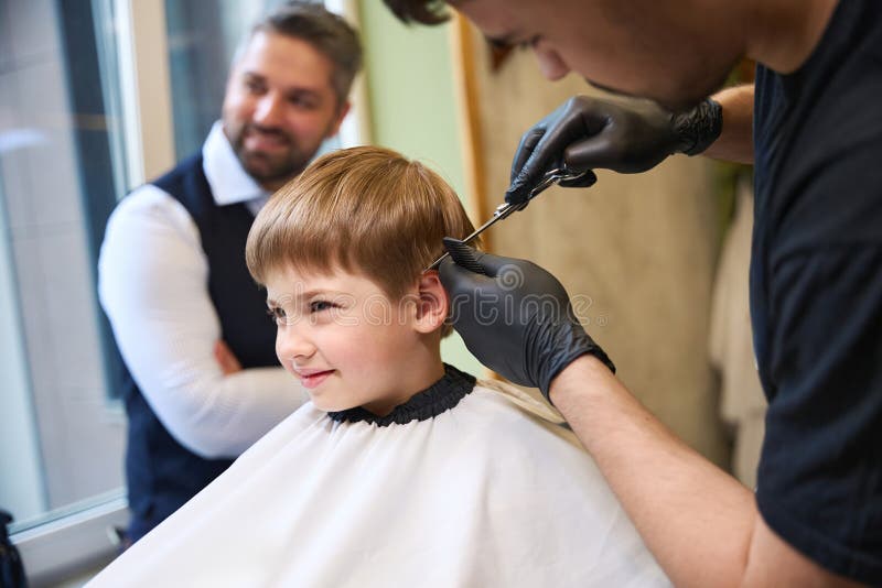 Experienced Master Using Scissors To Cut the Hair Above the Boy& X27;s ...