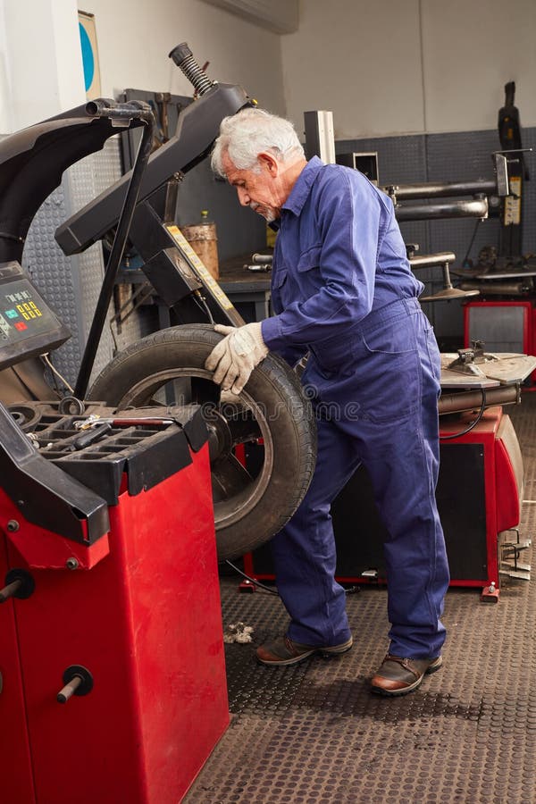 Experienced Mechanic in the Car Workshop with Tires Stock Image - Image ...