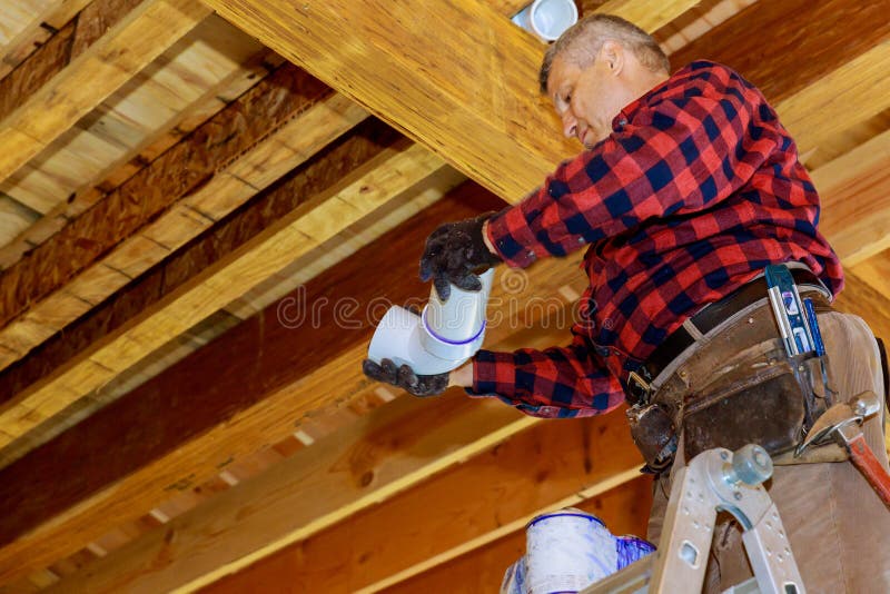 An Experienced Plumber Joins Plastic Pipes by Using Cement Glue on a ...