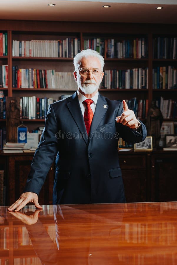 Experienced Rector Posing in Academic Library with Bookshelf Stock ...